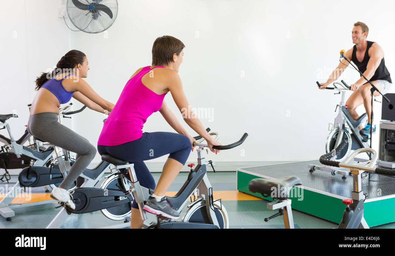 Spin class working out with motivational instructor Stock Photo - Alamy