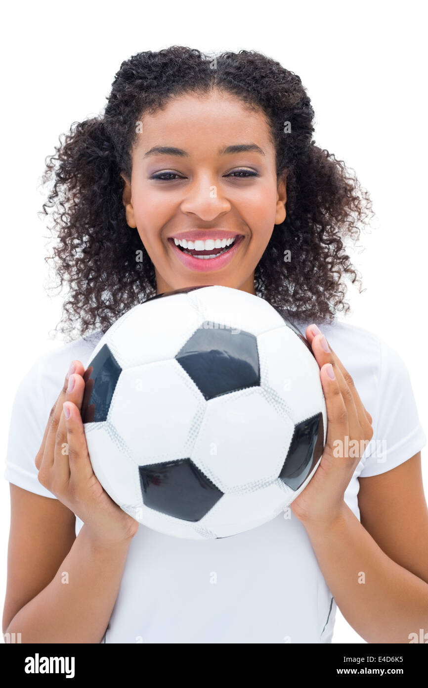 Pretty football fan in white holding ball smiling at camera Stock Photo ...