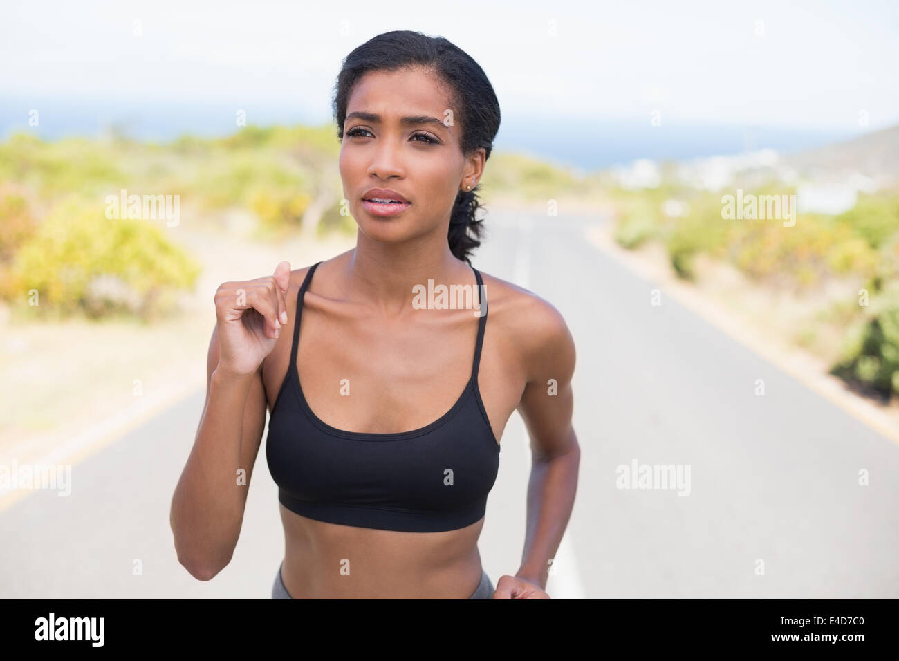Fit woman running along the open road Stock Photo - Alamy
