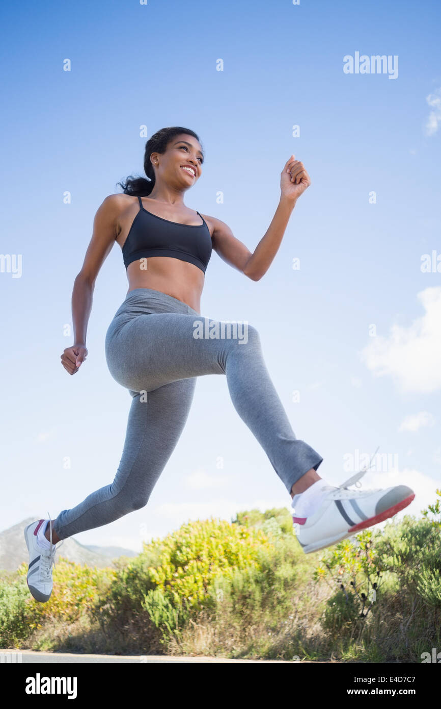 Fit woman running along the open road Stock Photo - Alamy