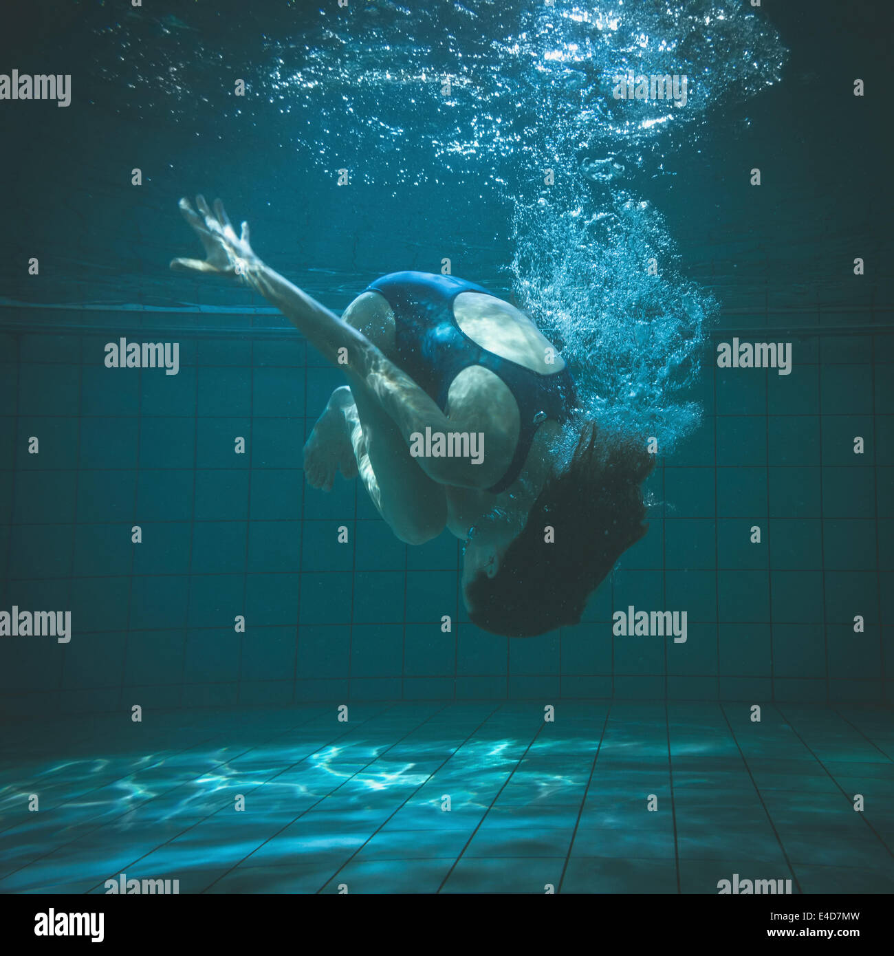 Athletic swimmer doing a somersault underwater Stock Photo - Alamy