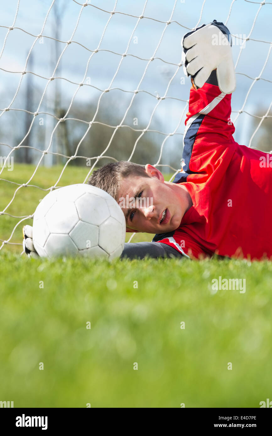 Goalkeeper in red making a save Stock Photo - Alamy