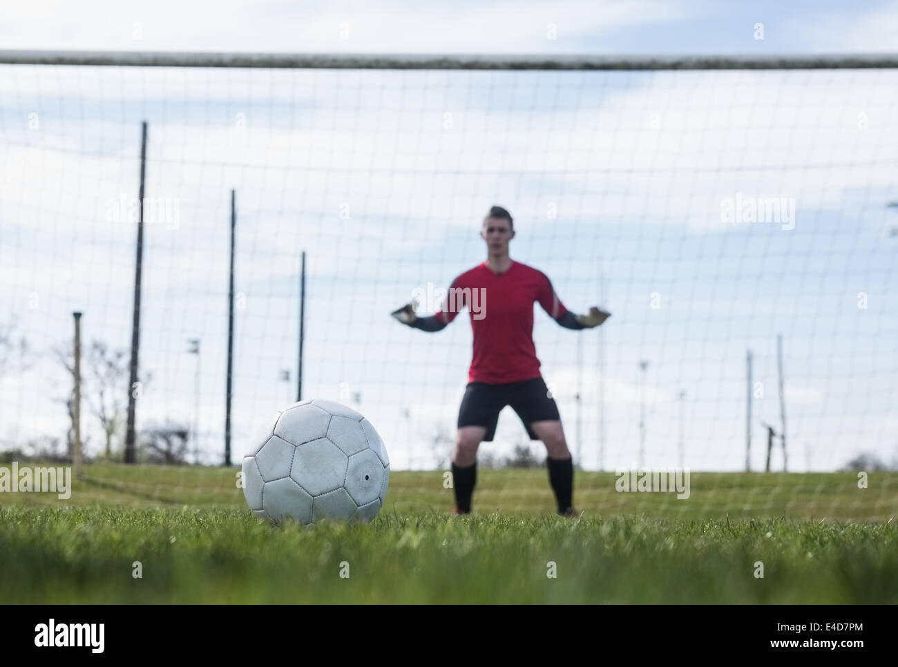 Goalkeeper in red ready to make a save Stock Photo - Alamy
