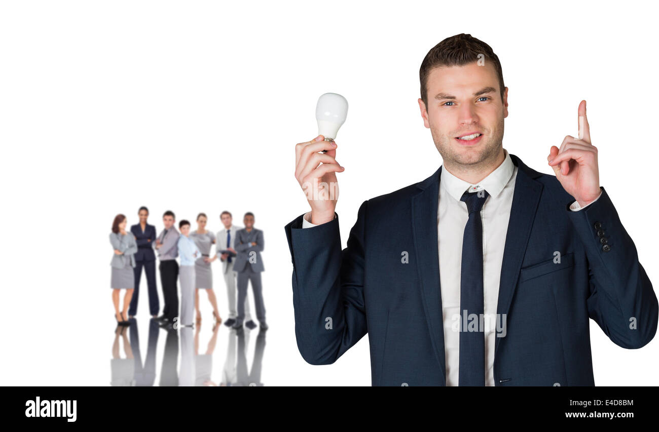 Composite image of businessman holding light bulb and pointing Stock ...