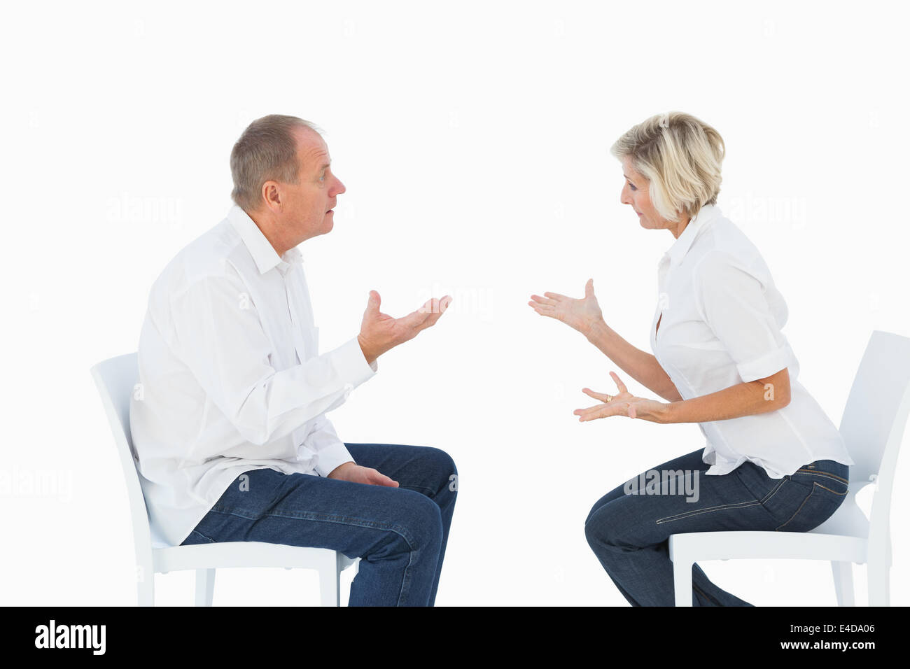 Older couple sitting in chairs arguing Stock Photo - Alamy
