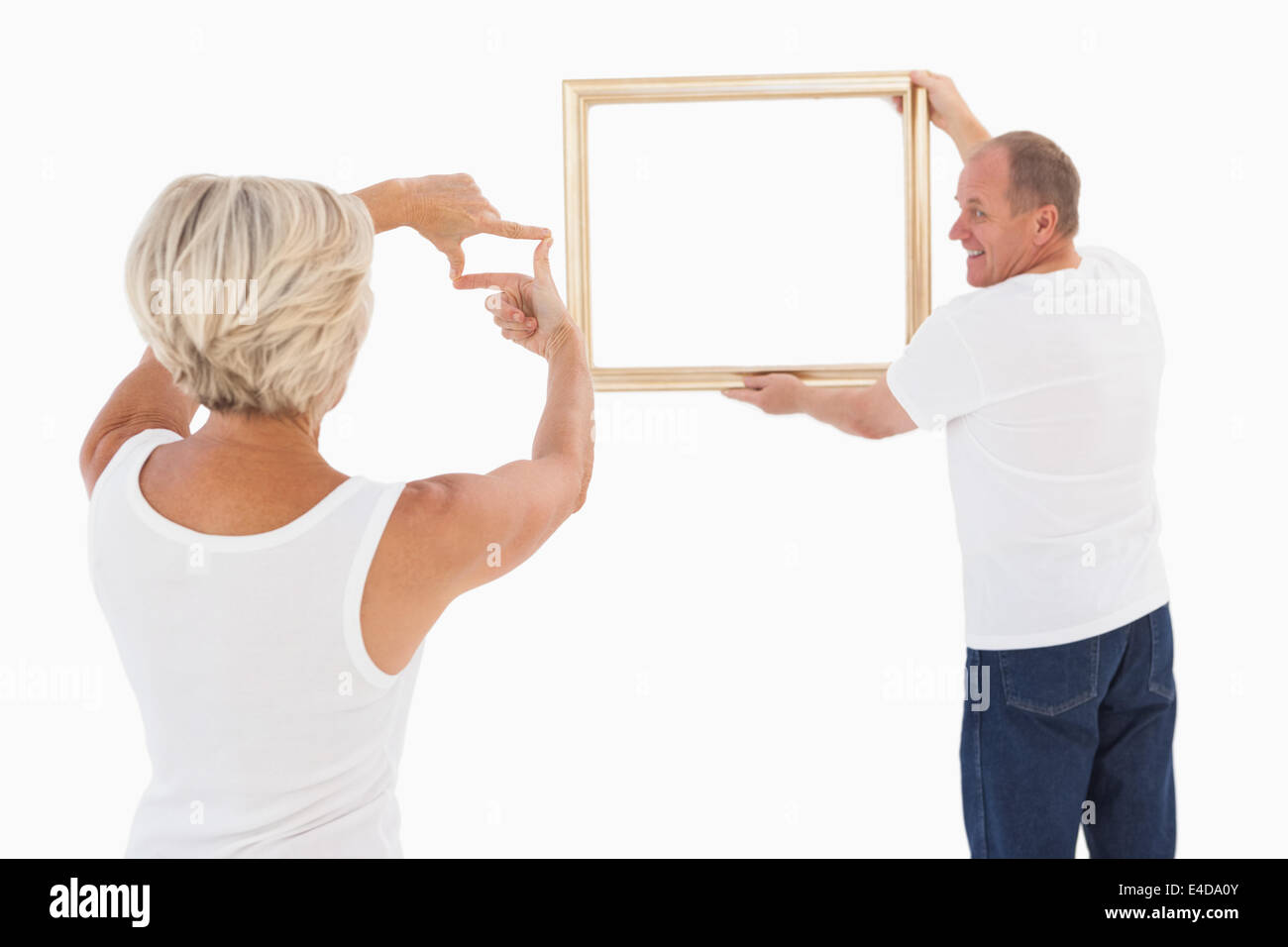 Mature couple hanging up picture frame Stock Photo - Alamy