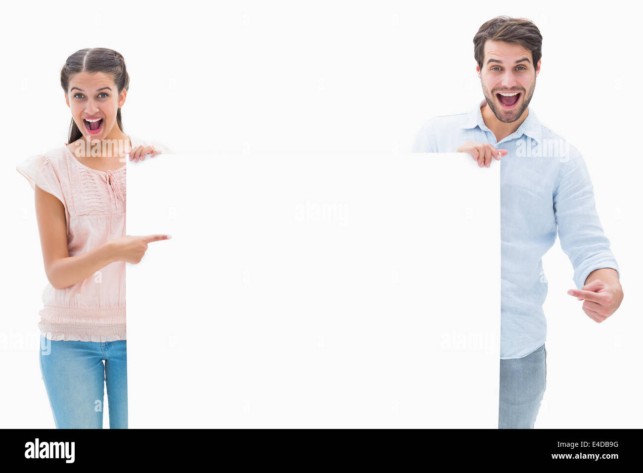Attractive young couple smiling at camera holding poster Stock Photo ...