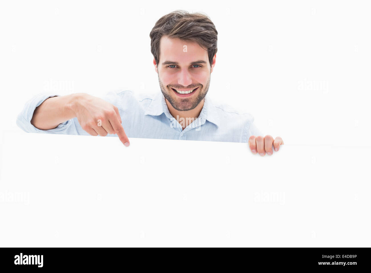 Attractive young man smiling and holding poster Stock Photo - Alamy