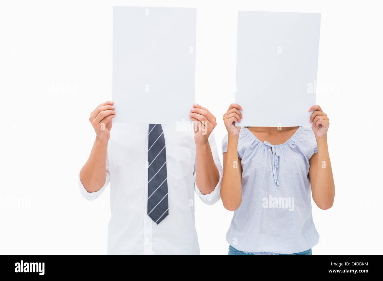 Couple holding paper over their faces Stock Photo - Alamy