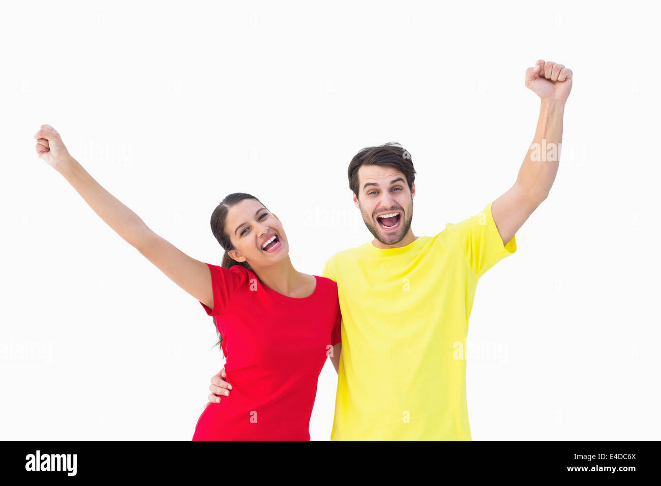 Excited couple cheering in red and yellow tshirts Stock Photo - Alamy