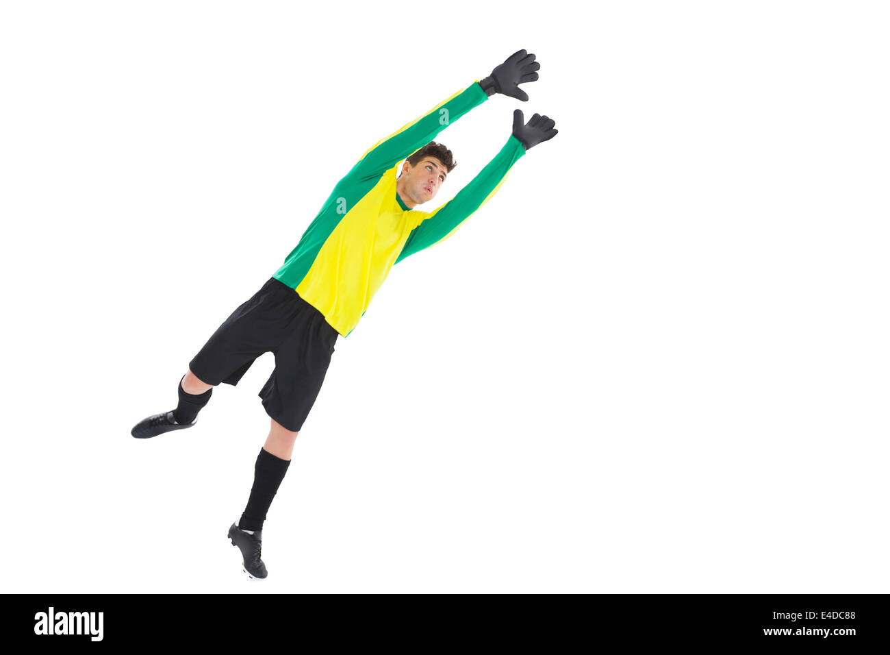 Goalkeeper in yellow jumping up Stock Photo - Alamy