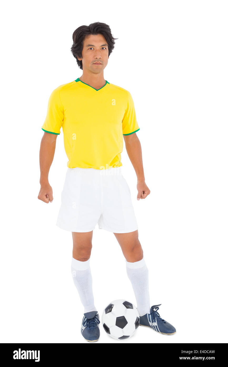 Football player in yellow with ball Stock Photo - Alamy