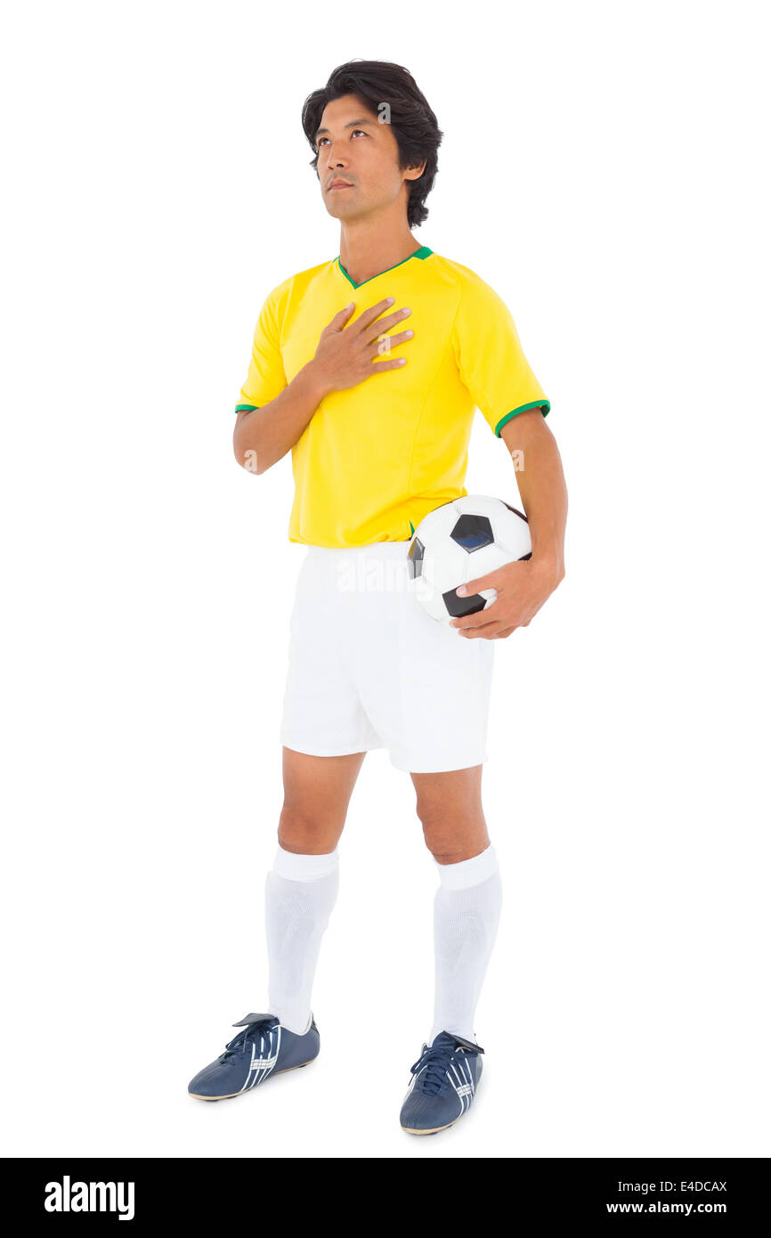 Football player in yellow with ball Stock Photo - Alamy