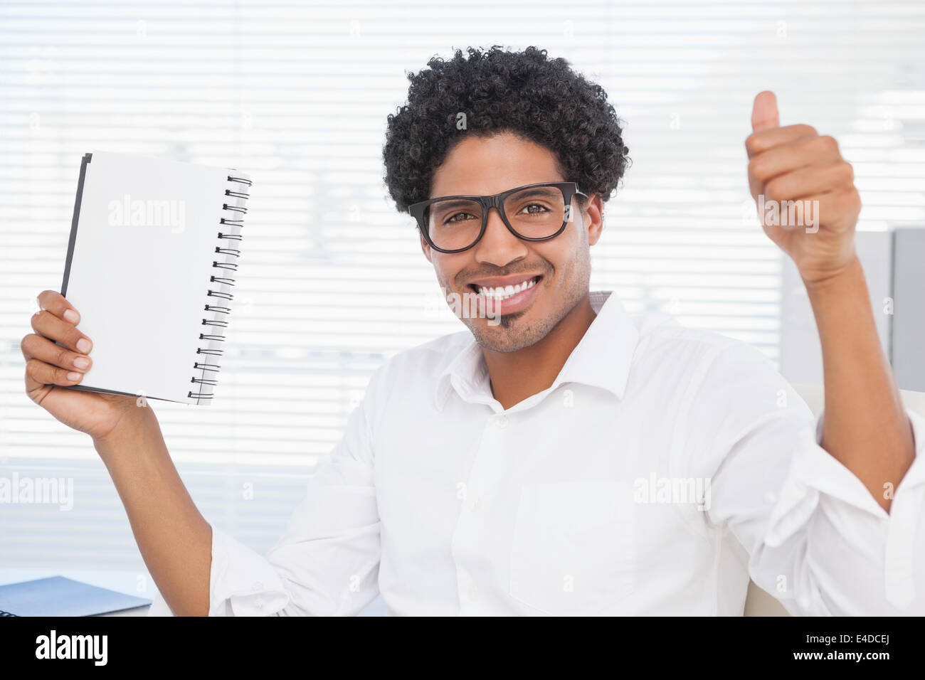 Happy businessman showing notepad and thumbs up Stock Photo - Alamy