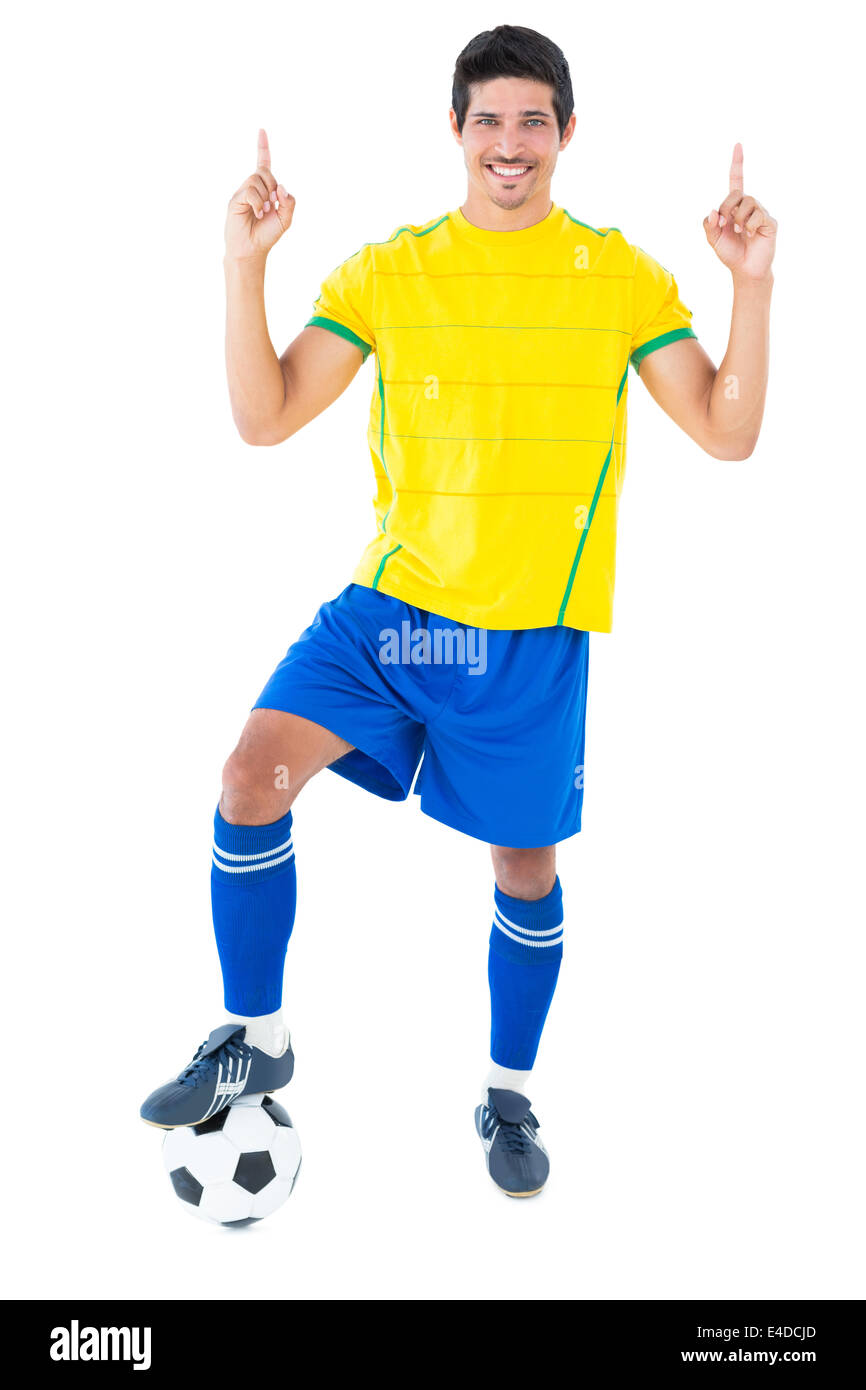 Football player in yellow with ball Stock Photo - Alamy