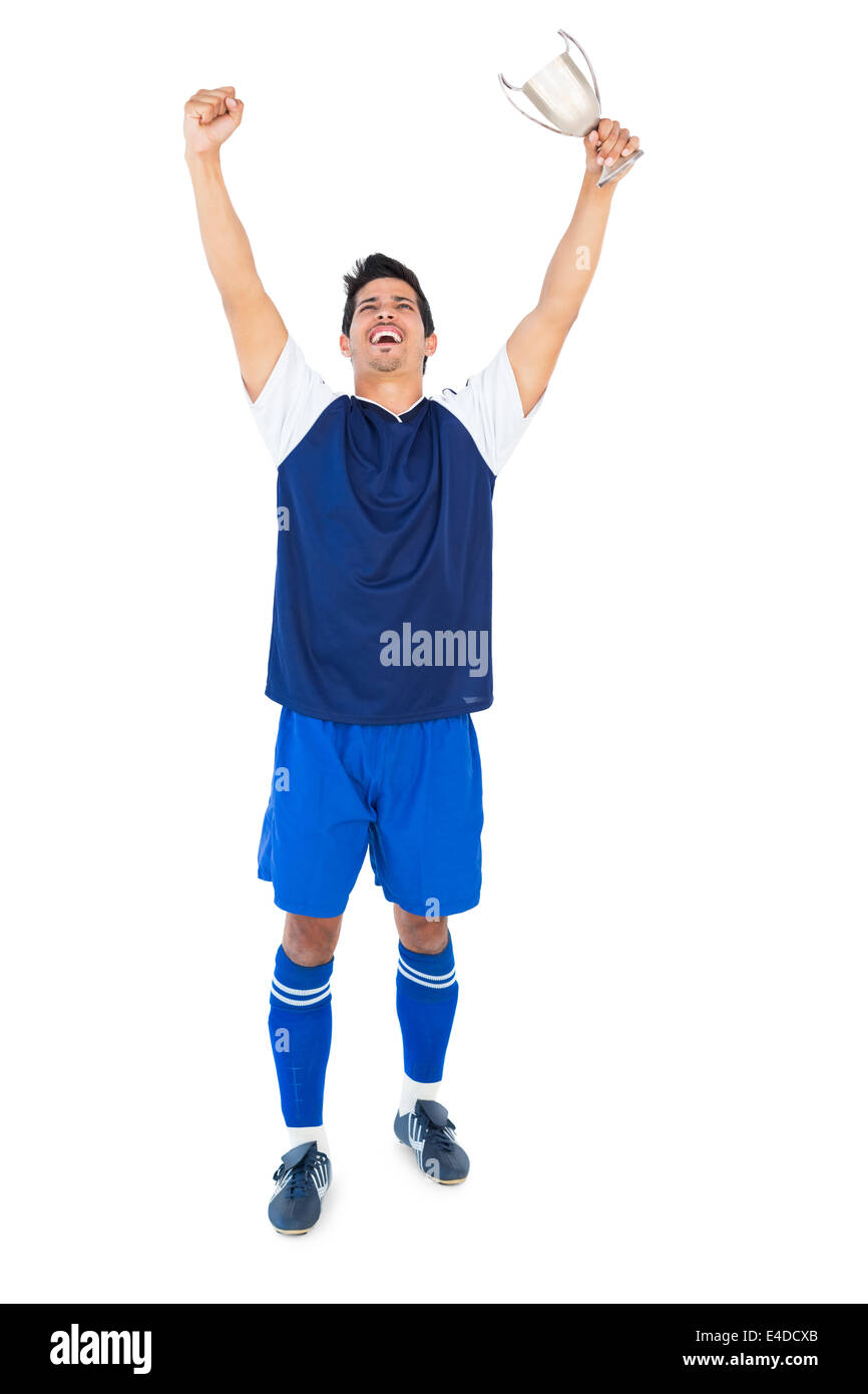 Football player in blue holding winners cup Stock Photo - Alamy