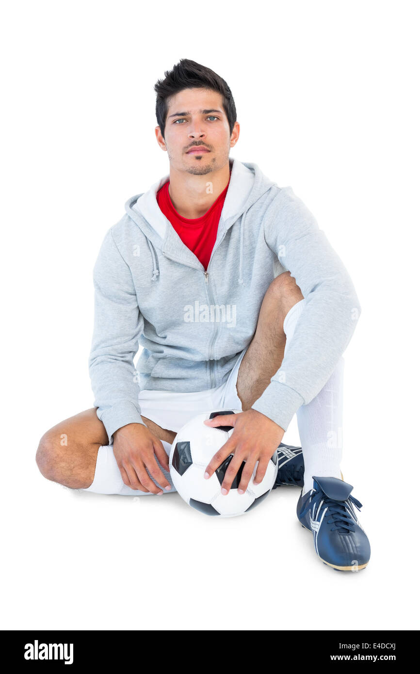 Football player sitting with ball Stock Photo - Alamy