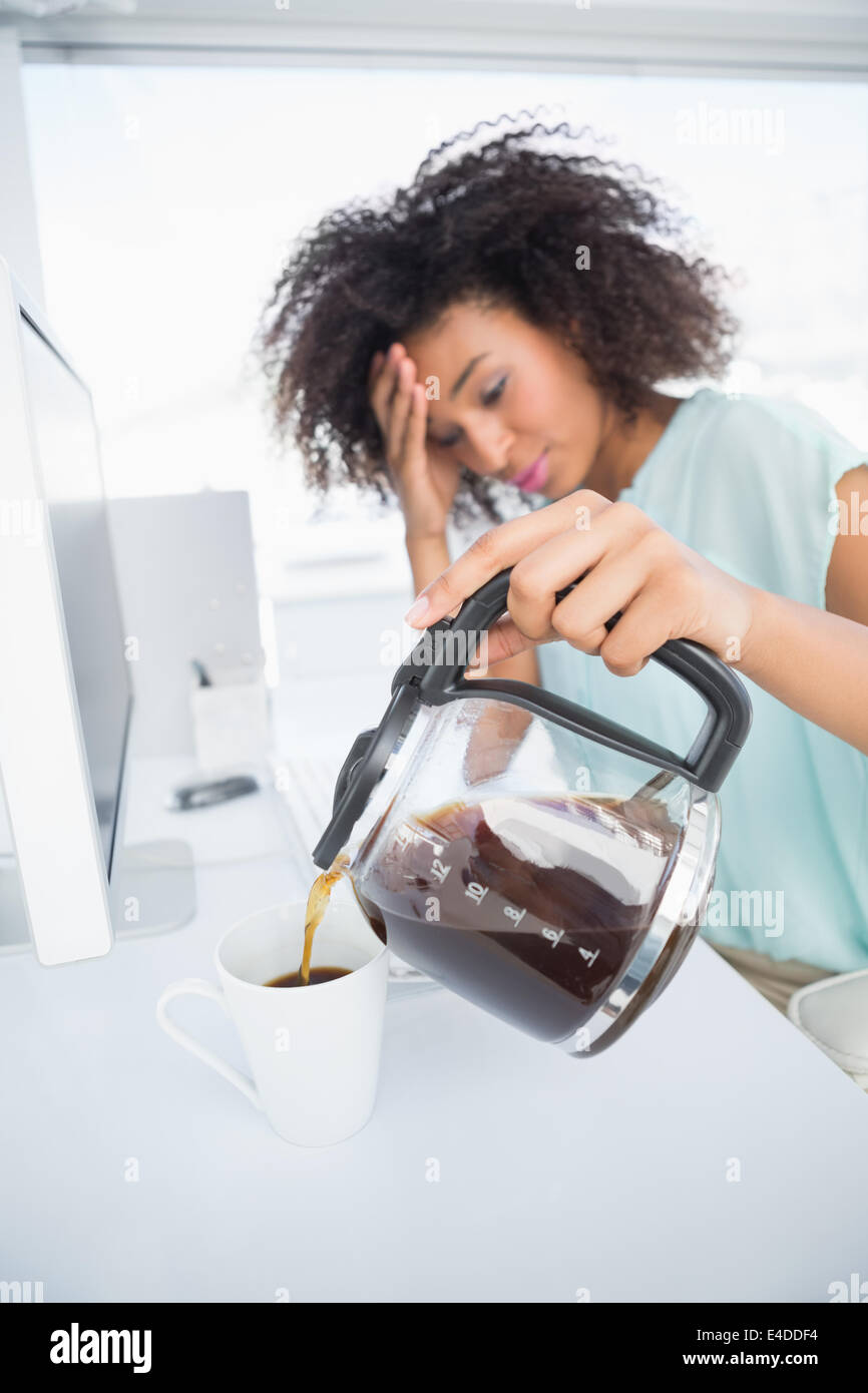 Tired businesswoman pouring a cup of coffee at desk Stock Photo - Alamy
