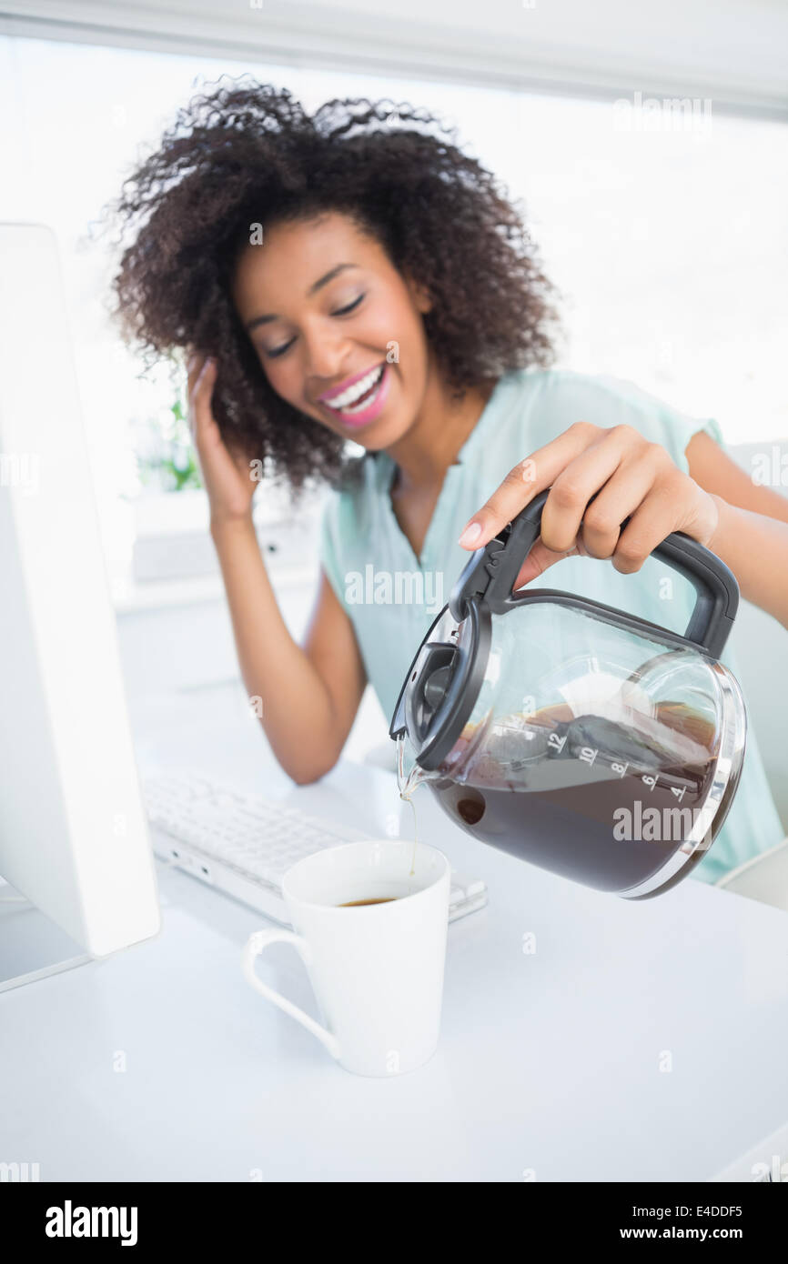 Tired businesswoman pouring a cup of coffee at desk Stock Photo - Alamy