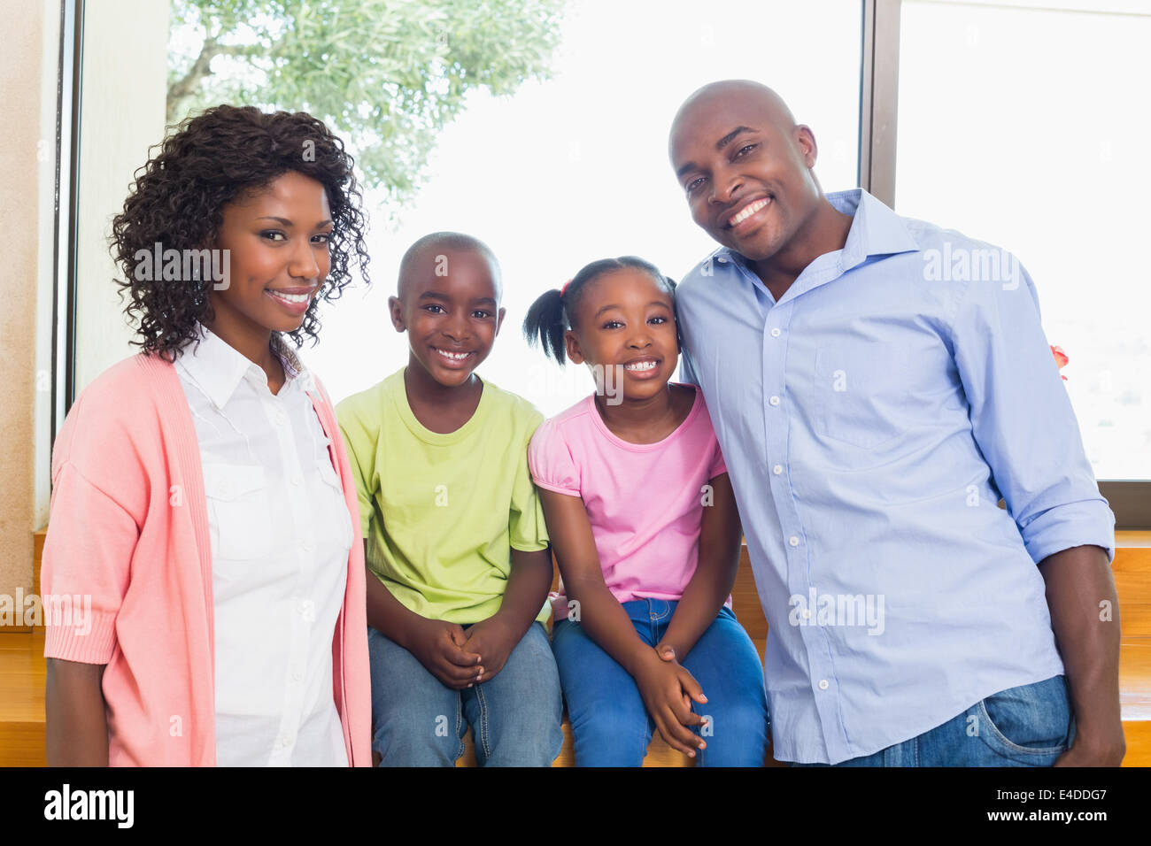 Happy family smiling at camera Stock Photo - Alamy