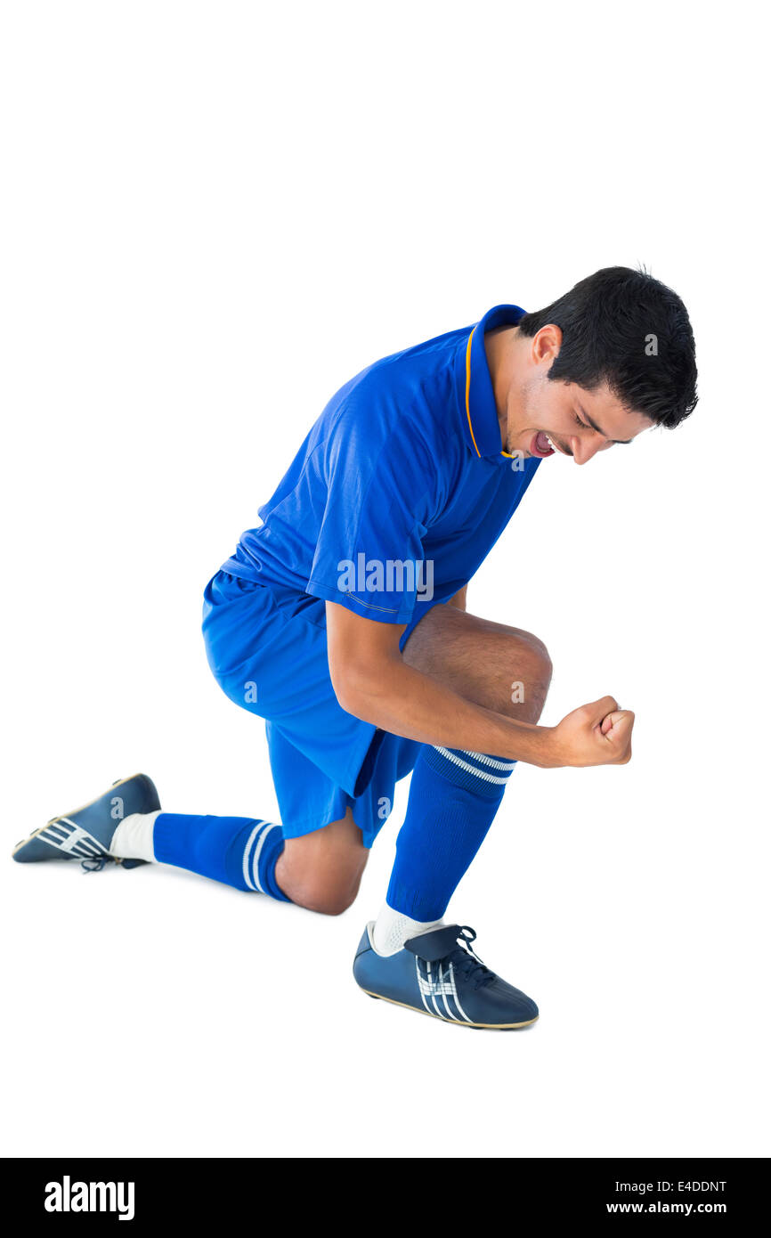 Happy football player in blue celebrating Stock Photo - Alamy