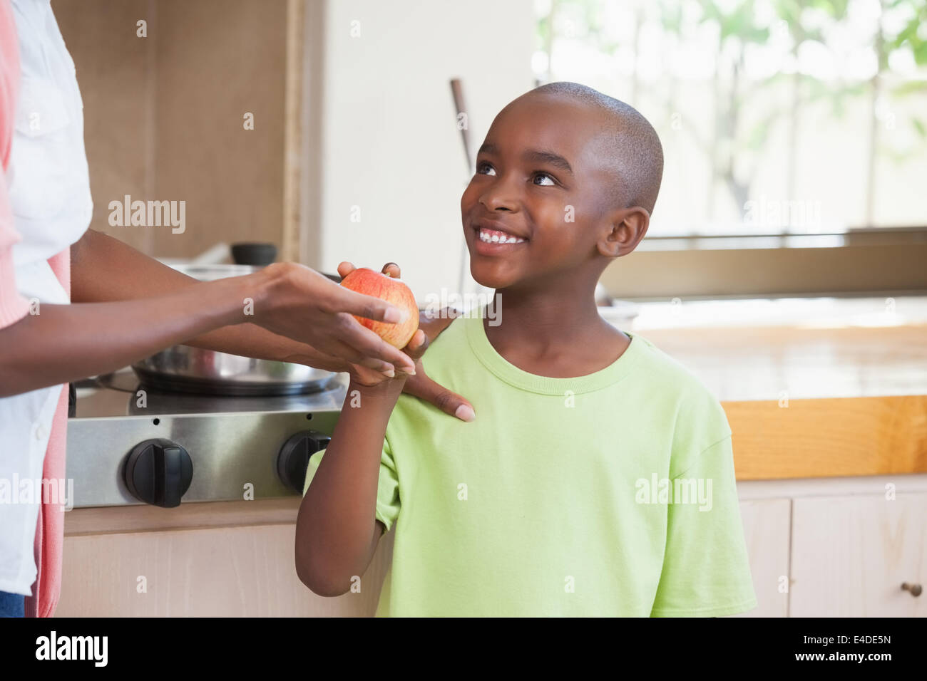 Little boy taking an apple from his mother Stock Photo - Alamy