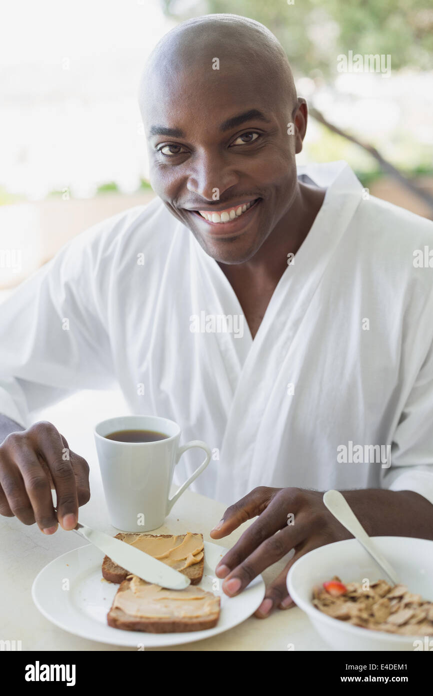 Handsome man in bathrobe having breakfast outside Stock Photo - Alamy