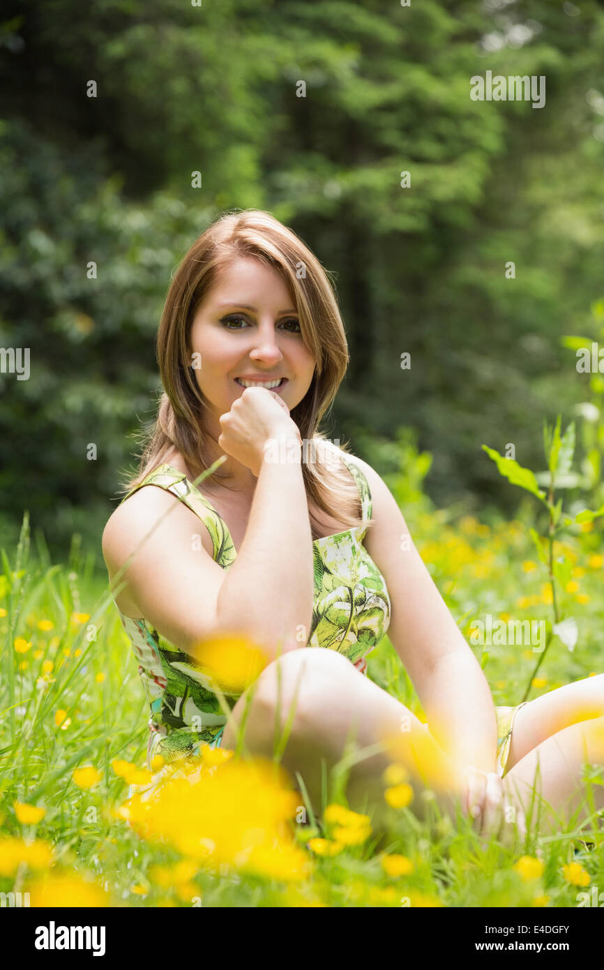 Cute young woman relaxing in field Stock Photo - Alamy