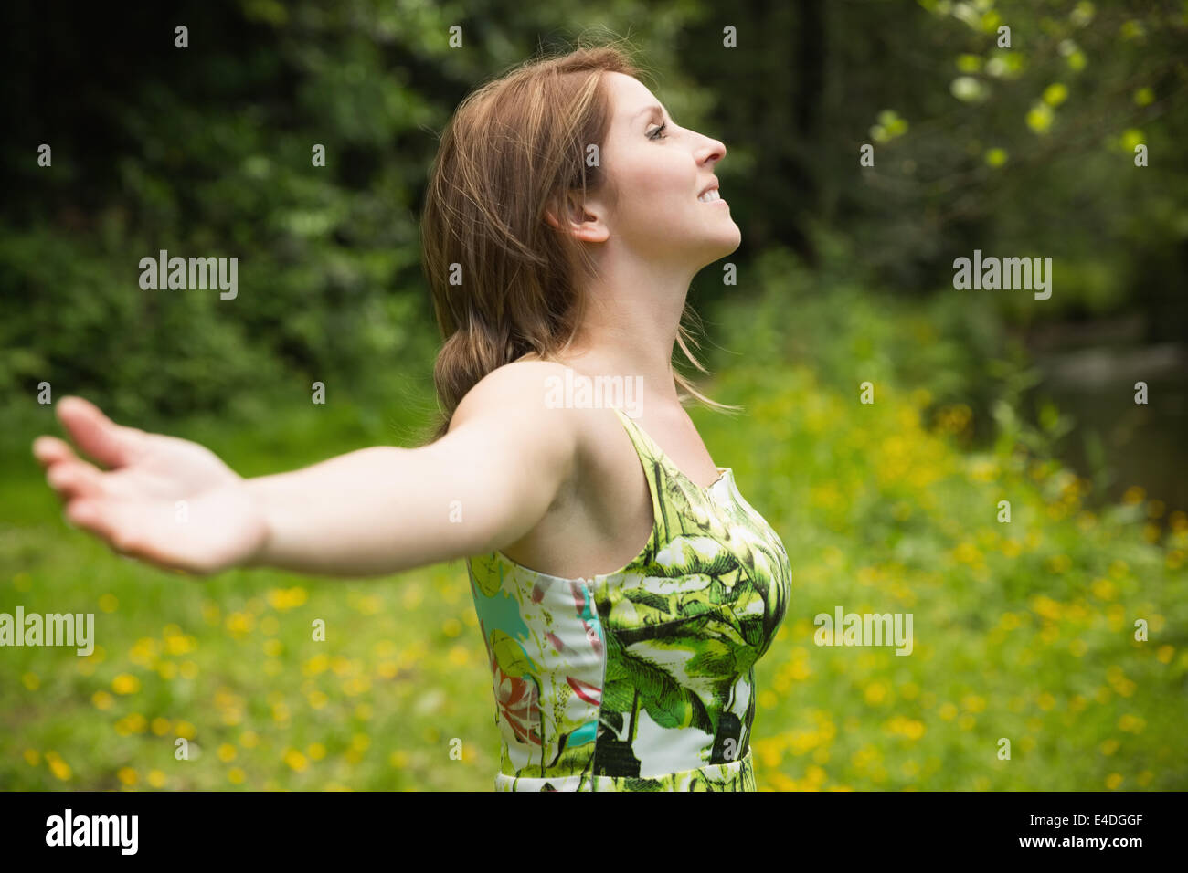 Woman with arms outstretched in field Stock Photo - Alamy