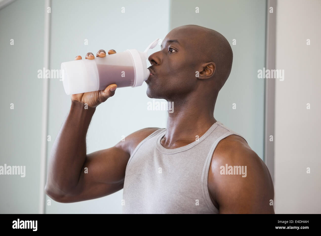 Sporty man drinking protein in gym Stock Photo - Alamy