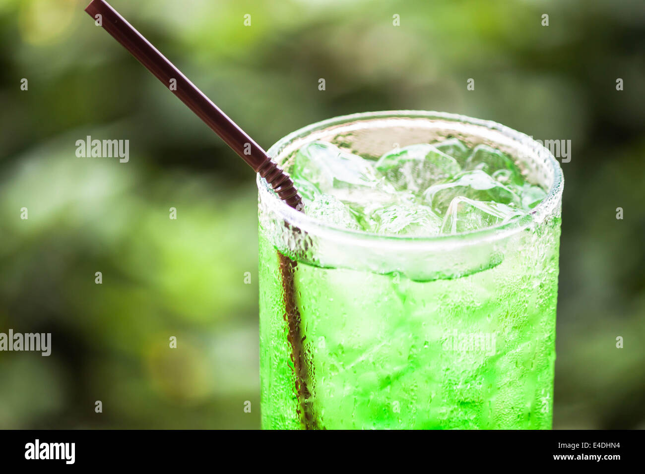 Glass of iced green drink with straw Stock Photo - Alamy