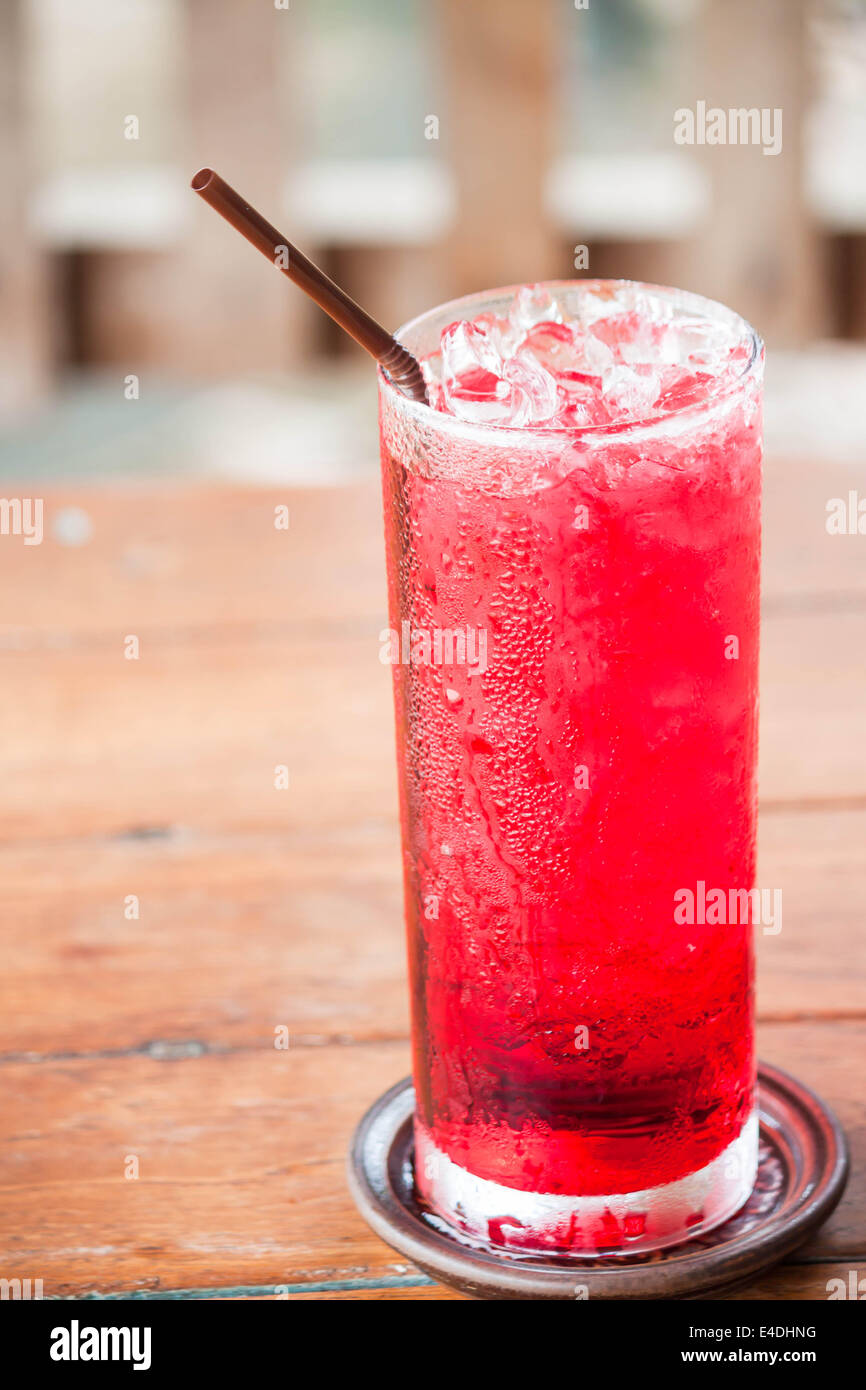 Glass of iced red drink with straw Stock Photo - Alamy