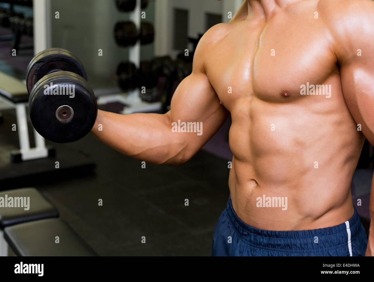 Mid section of shirtless muscular man exercising with dumbbell Stock ...