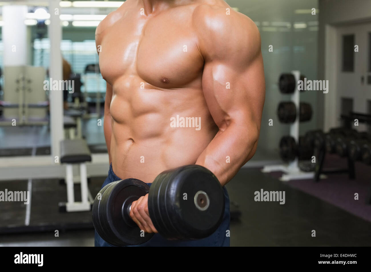Mid section of shirtless muscular man exercising with dumbbell Stock ...
