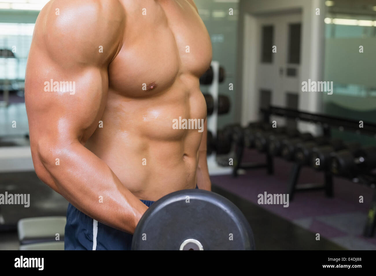 Mid section of shirtless muscular man exercising with dumbbell Stock ...