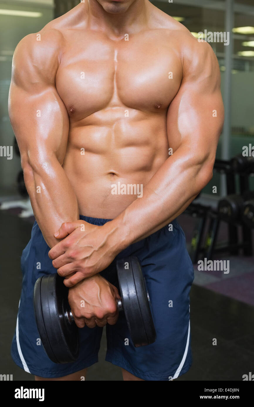 Mid section of shirtless muscular man exercising with dumbbell Stock ...
