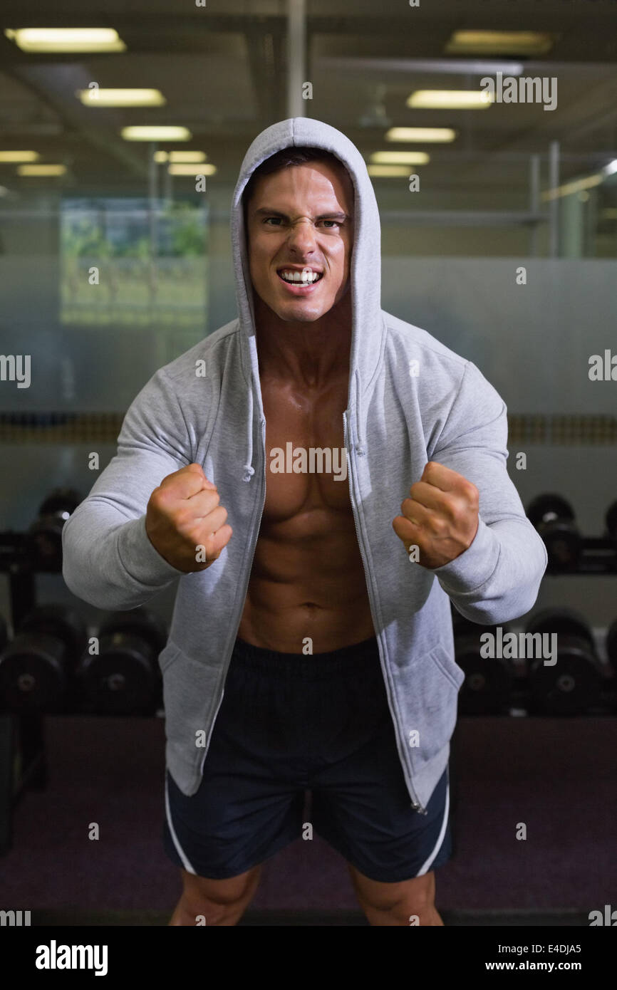 Muscular man clenching fists in health club Stock Photo - Alamy