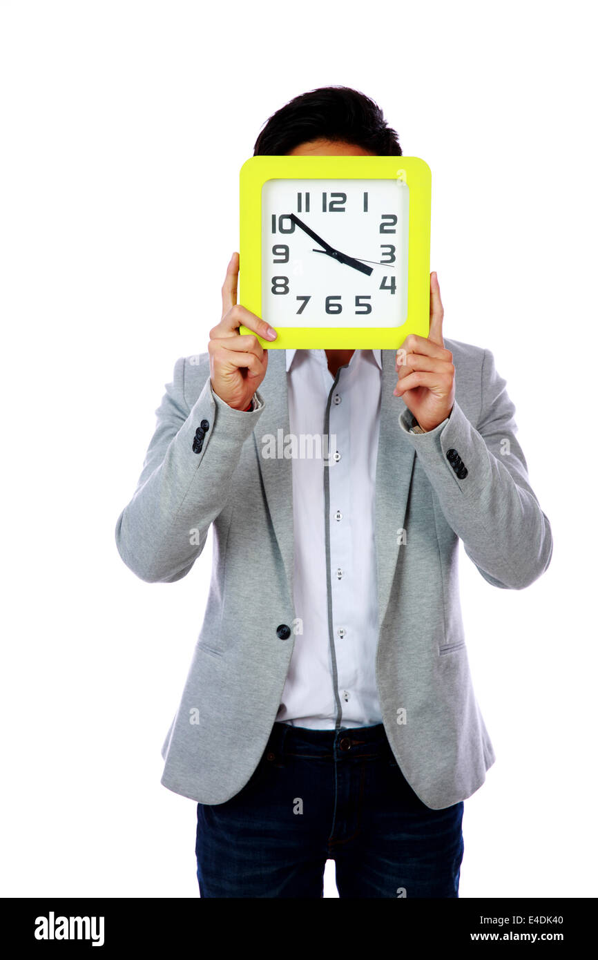 Young man holding clock covering his face over white background Stock ...
