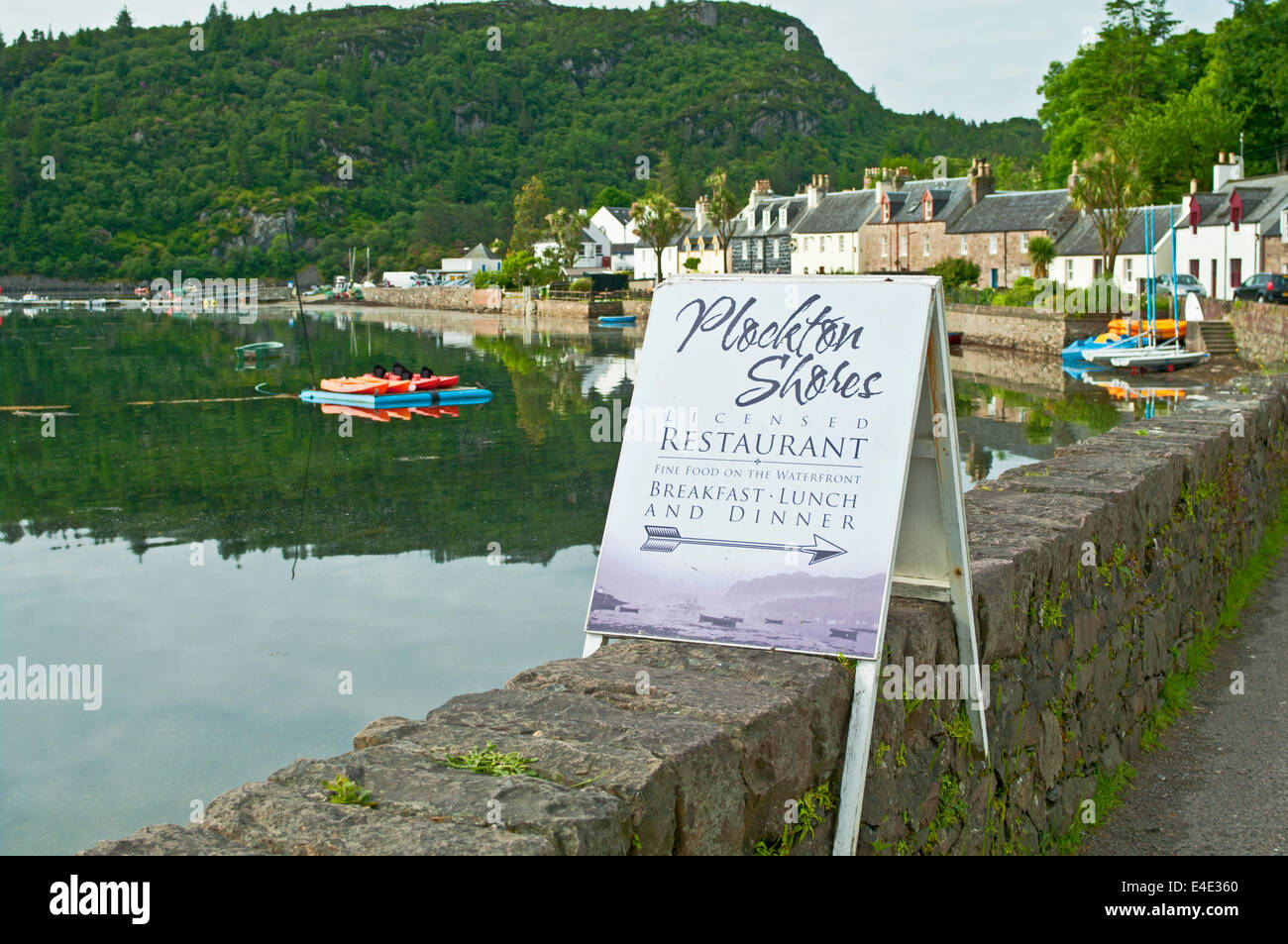 Wooden sign advertising Plockton Shores Restaurant on harbour wall in ...
