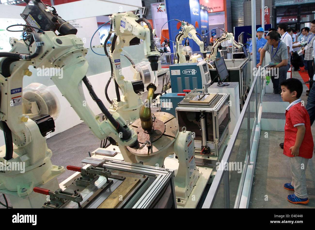 Shanghai, China. 9th July, 2014. A boy is attracted by robots for ...
