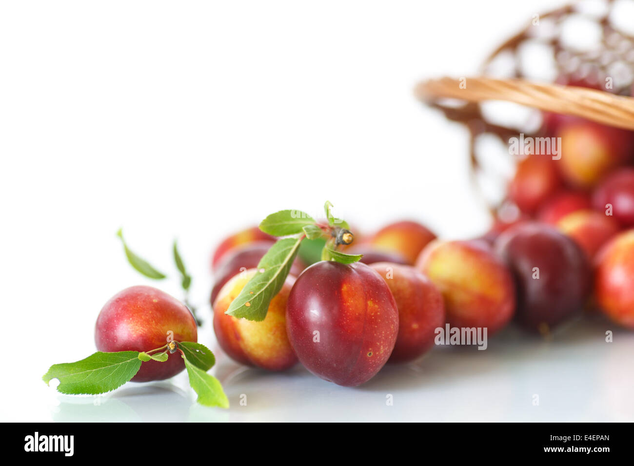 ripe red plums on a table on a white background Stock Photo - Alamy