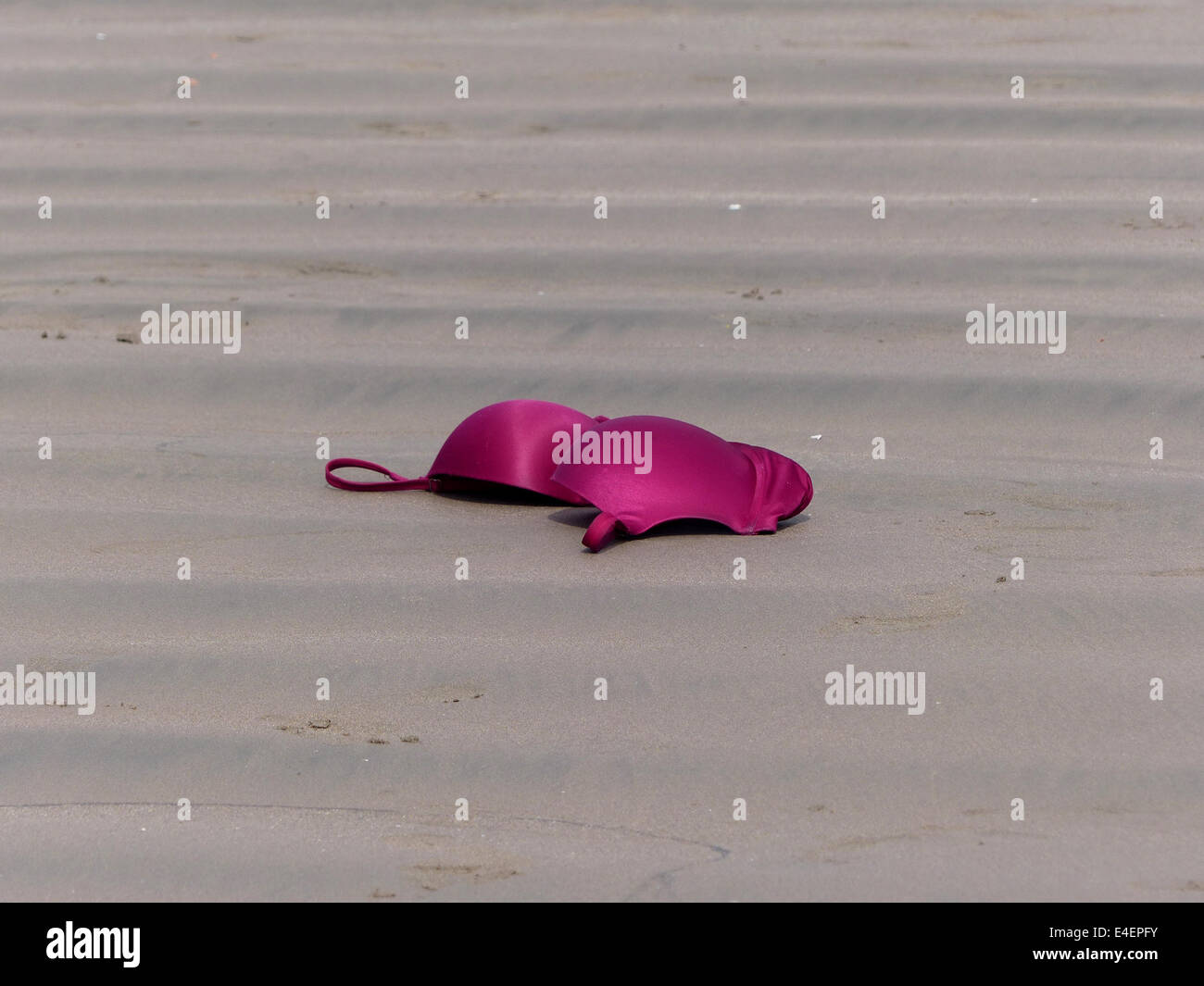 An abandoned pink bra or bikini top lying on a beach Stock Photo - Alamy