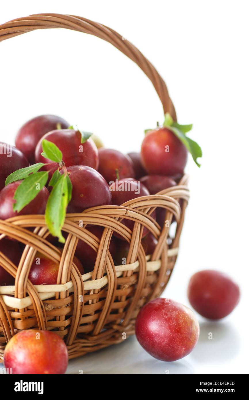 ripe red plums on a table on a white background Stock Photo - Alamy