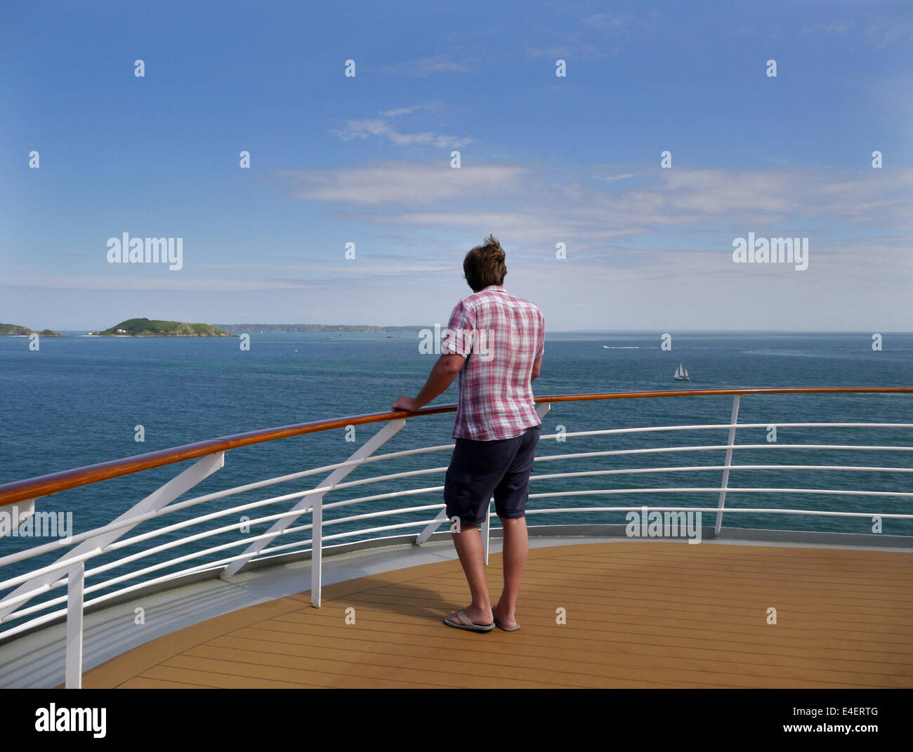 A cruise ship passenger looking out to sea from the top deck Stock ...