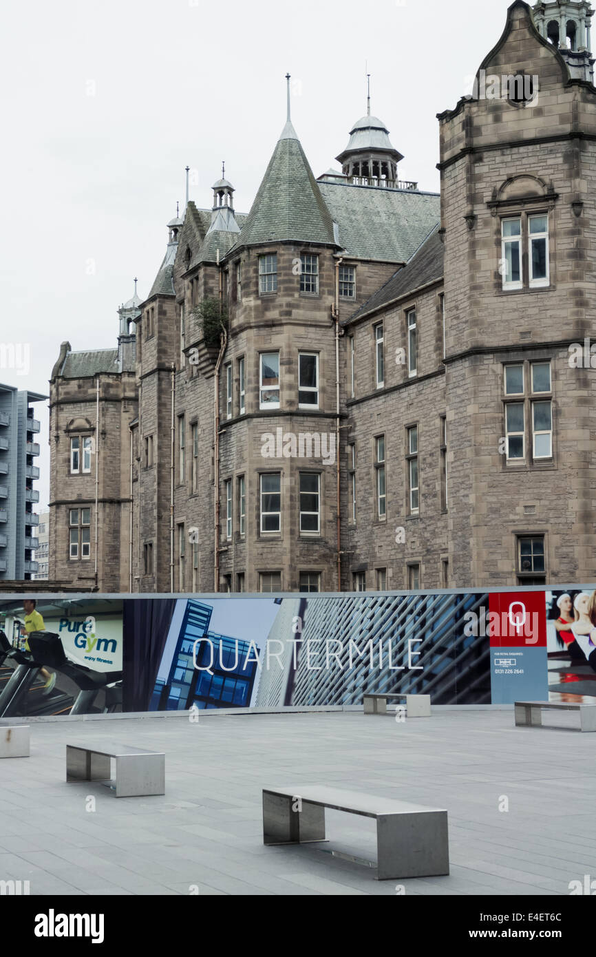 Billboards and metal benches in front or an old building in the ...