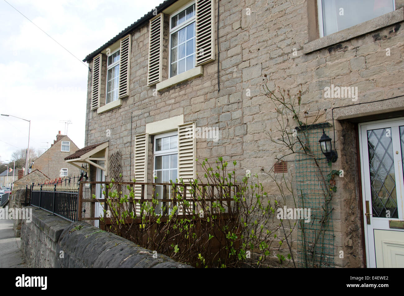 Mock shutters and upvc doors and windows on a traditional limestone ...
