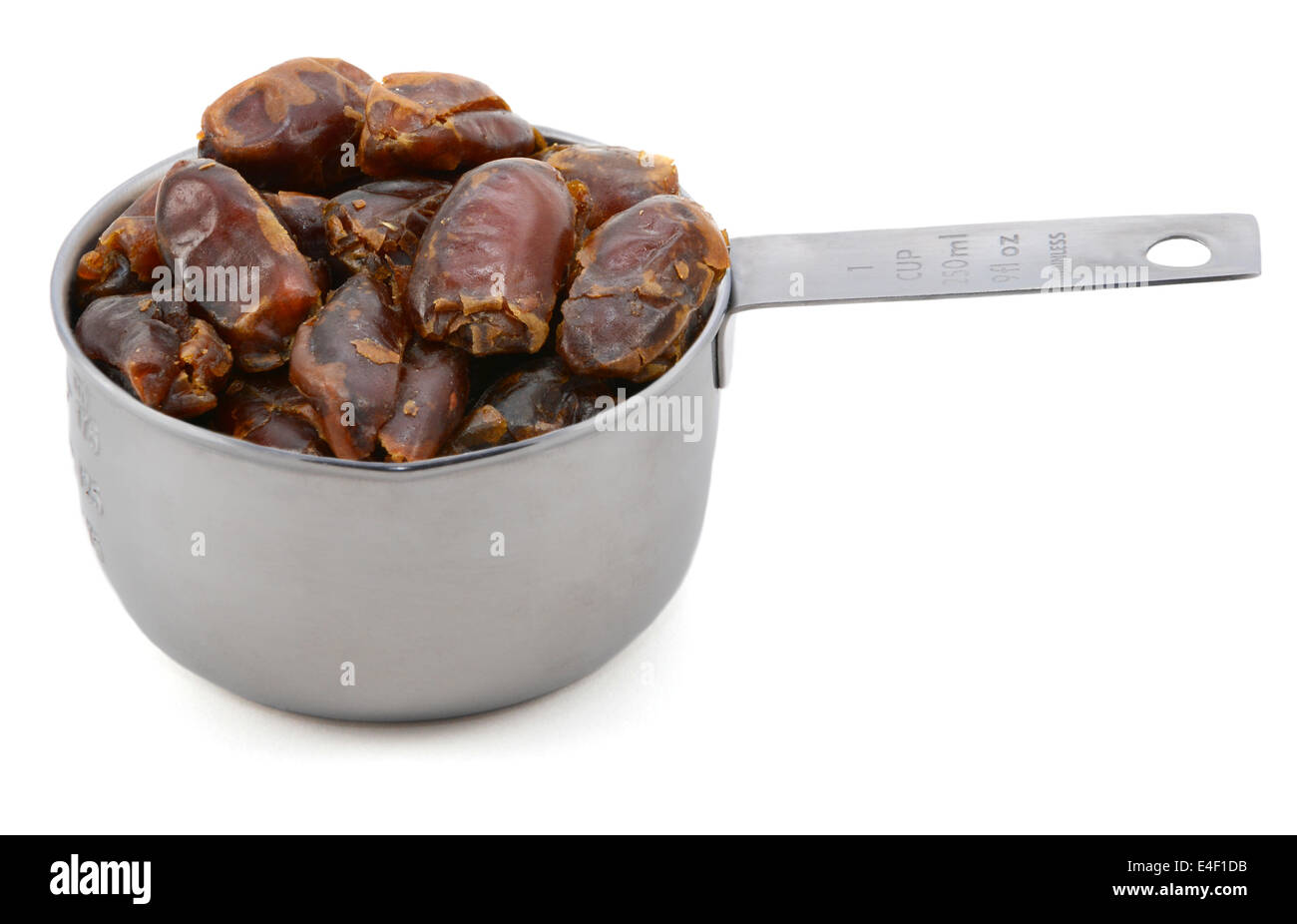 Sticky whole dates in an American cup measure, isolated on a white ...