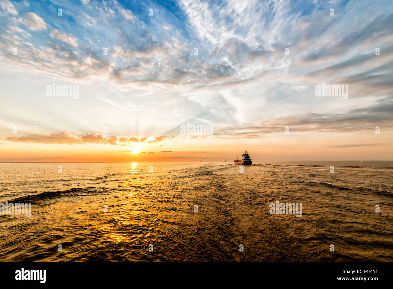 Amazing Sunset. Empty container ship is sailing along the waterway ...