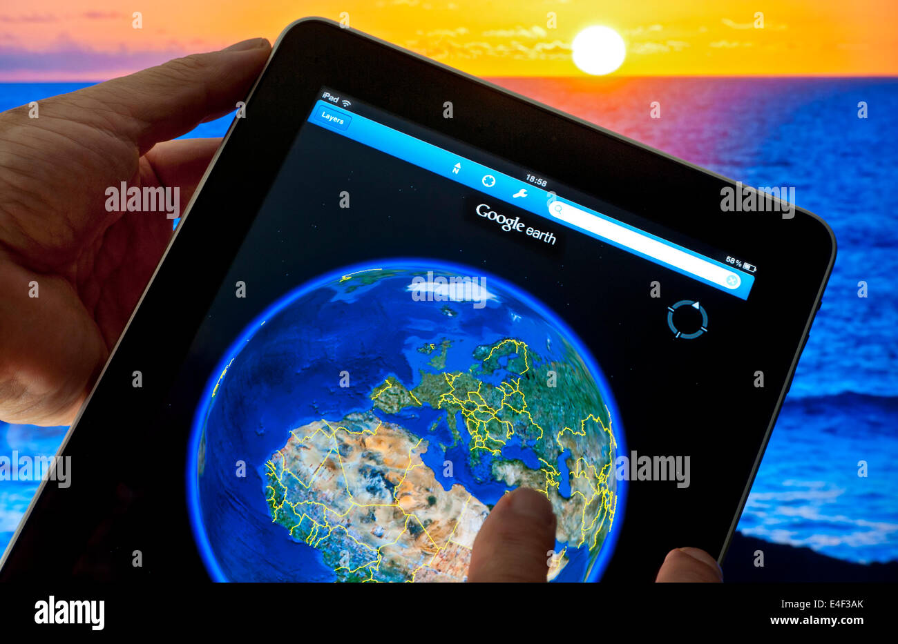 Apple iPad smart tablet & hands with Google Earth featuring world globe ...