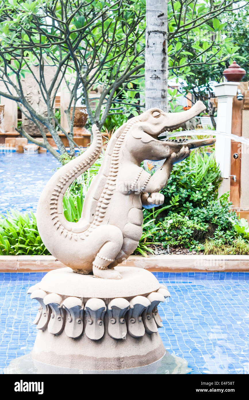 Crocodile statue spray water decorated blue pool Stock Photo - Alamy